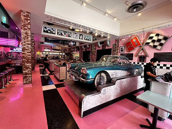 A classic Corvette gleams under pink neon lights, serving as both centerpiece and time machine. Who needs a DeLorean when you've got this beauty?