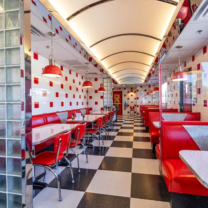 Classic black and white checkered floors lead you down a tunnel of red vinyl comfort. If Norman Rockwell designed a diner cathedral, this would be it.
