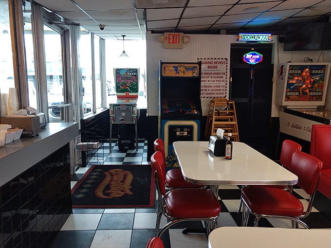 Classic red vinyl meets checkerboard floors in this time capsule where arcade games still blink in the corner, waiting for quarters.
