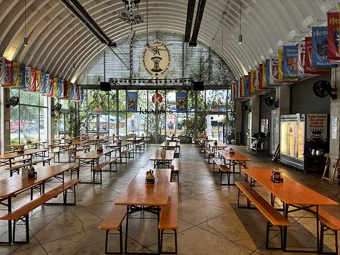 Imagine Oktoberfest year-round! The biergarten's arched ceiling, communal tables, and colorful flags create a space where strangers become friends over pretzels and pints.