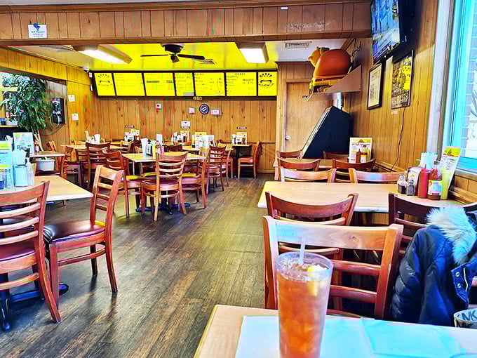 Wood paneling and cherry-red chairs create that perfect time-capsule diner atmosphere where conversations flow as freely as the sweet tea.