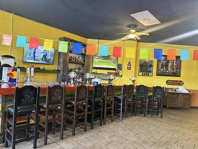 Colorful papel picado banners dance overhead while carved wooden chairs invite you to settle in for a fiesta of flavors.