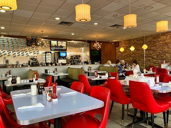 Step into a time capsule of Americana where red chairs pop against stone walls and every table feels like the best seat in the house.