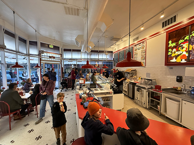 Inside this temple of dairy devotion, the black and white checkered floor and red pendant lights create the perfect backdrop for ice cream epiphanies.