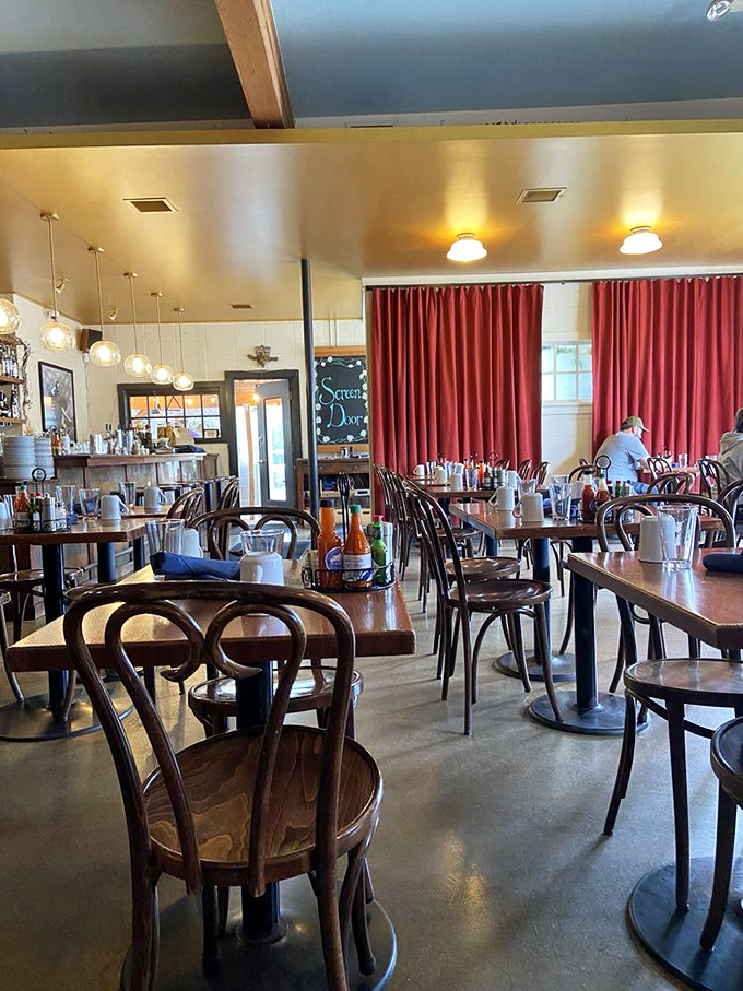 Bentwood chairs, warm lighting, and those signature red curtains create the perfect backdrop for Southern comfort food magic.