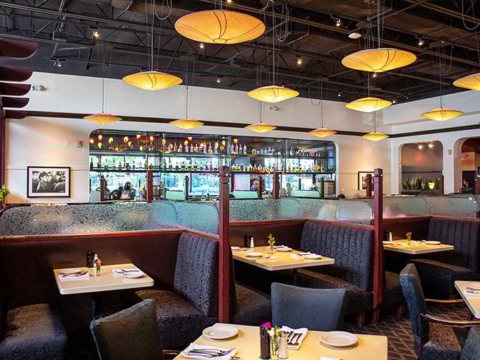 Warm pendant lighting casts a golden glow over intimate booths where food conversations flow as freely as the sweet tea.