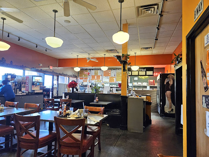 Warm orange walls, pendant lights, and that unmistakable New York skyline silhouette &ndash; walking in here is cheaper than a plane ticket to JFK.