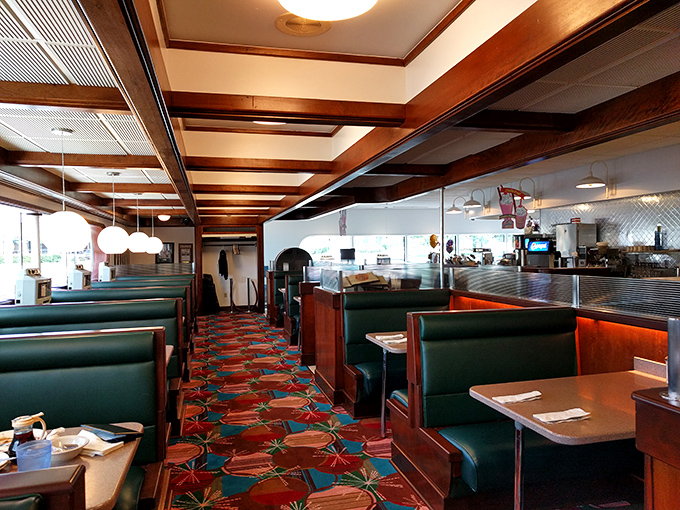 Sliding into these teal vinyl booths feels like time travel. The wooden ceiling beams and patterned carpet scream "authentic diner experience."