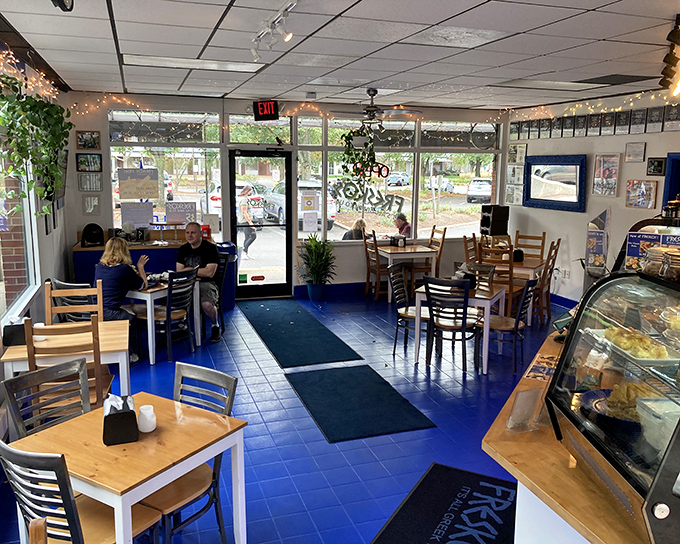 Step inside to a world where vibrant blue floors meet warm wooden tables, creating a casual atmosphere that feels like a neighborhood taverna in the heart of New England.