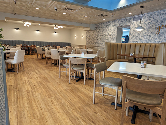 Modern comfort defines the interior with warm wood floors, blue patterned walls, and plush seating that invites you to linger over that second coffee.