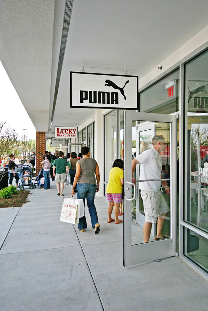 Retail therapy in full swing! Shoppers navigate the covered walkways of Williamsburg Premium Outlets, bags in hand and savings in pocket.