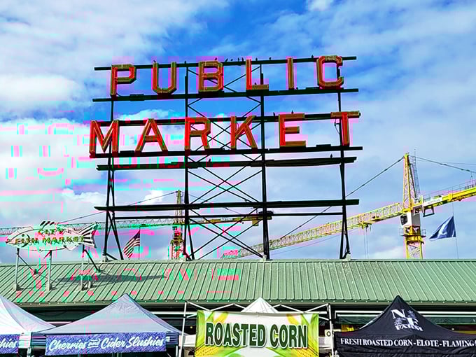 The famous Pike Place Market sign stands tall above a bustling seafood paradise. Seattle's seafood theater awaits below!