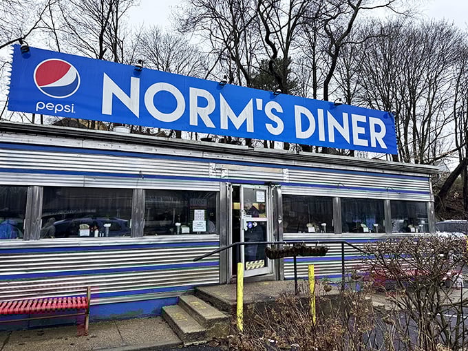 Norm's Diner winter view: "Even in Connecticut winter, Norm's blue-and-silver facade stands like a sentinel of sustenance, promising warmth via pancakes and coffee."