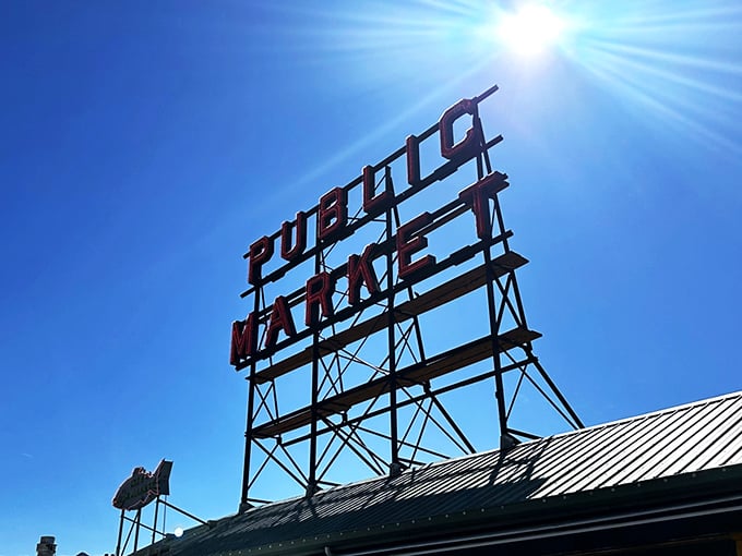 Sunshine illuminates Seattle's most famous market sign. Below it, fish fly through the air and fresh catches await.