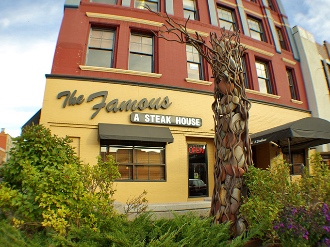 The Famous Steakhouse (entrance): "Where steak dreams and artistic metal trees meet. Come for the beef, stay for the unexpected beauty."