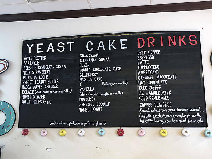The menu board&mdash;a monument to possibilities. Each chalked word represents not just a donut variety but a potential moment of pure, sugar-glazed bliss.