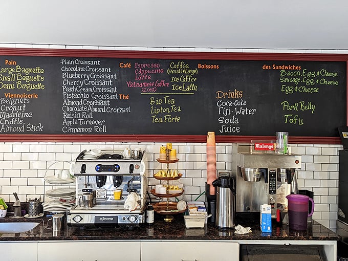 The chalkboard menu reads like a love letter to French pastry, with each item promising a different path to carbohydrate nirvana. 