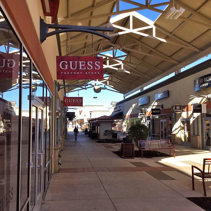 Sunlight streams through the open-air design, creating the perfect lighting for spotting that elusive 70% off tag at the Guess Factory Store.