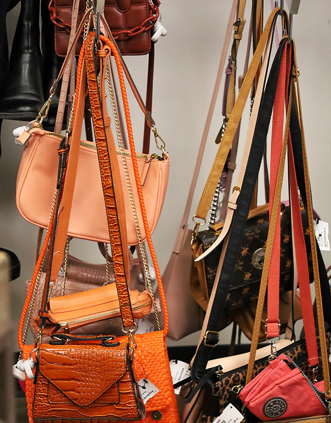The handbag section resembles a colorful leather garden where designer dreams bloom at prices that won't wilt your wallet.