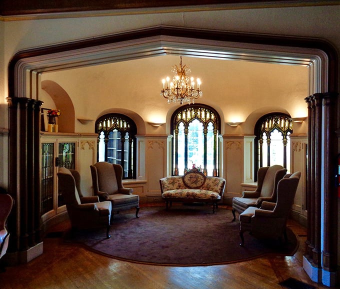 Elegant furnishings and Gothic-inspired windows transform this sitting room into a space where you half expect to find Downton Abbey characters discussing estate matters.