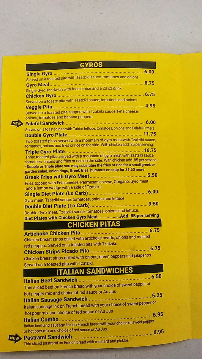 The vibrant yellow menu board reads like a love letter to Mediterranean cuisine, with gyros taking center stage in this culinary production.