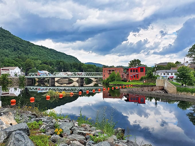 The Deerfield River flows beneath the iconic bridge, creating mirror-perfect reflections that would make even the most jaded Instagram influencer put down their phone and simply stare.