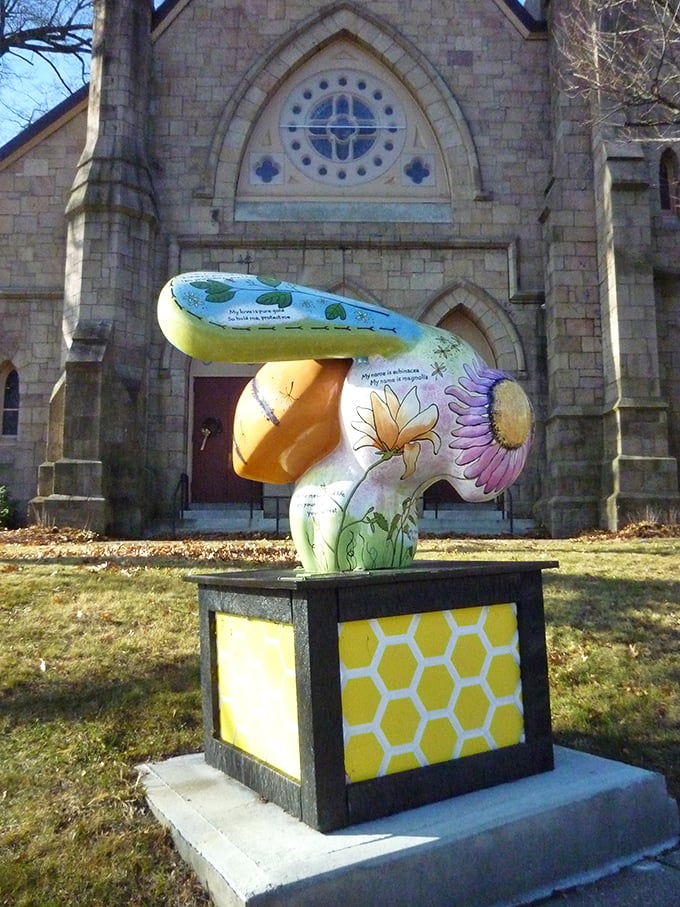 In Greenfield, you can admire this whimsical bee sculpture, blooming with floral art and local charm outside a historic stone church.