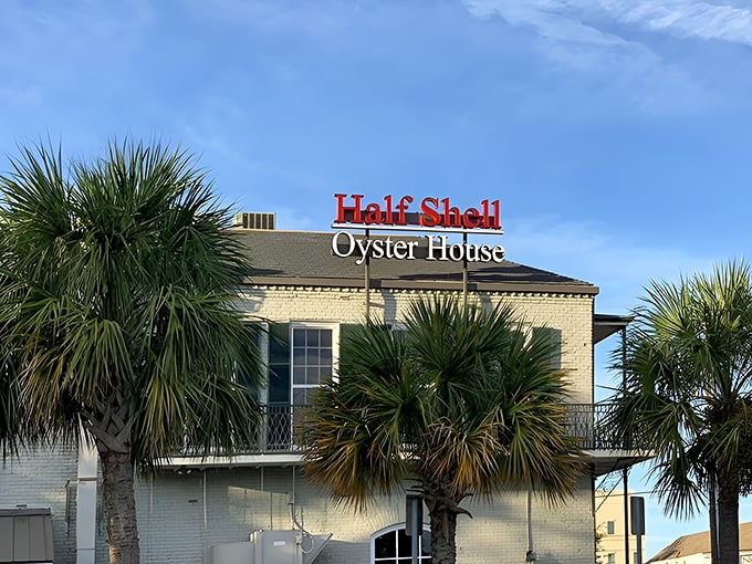 Palm trees frame the Half Shell's sign like nature's way of pointing and saying, "Psst... the oysters in here will change your life."