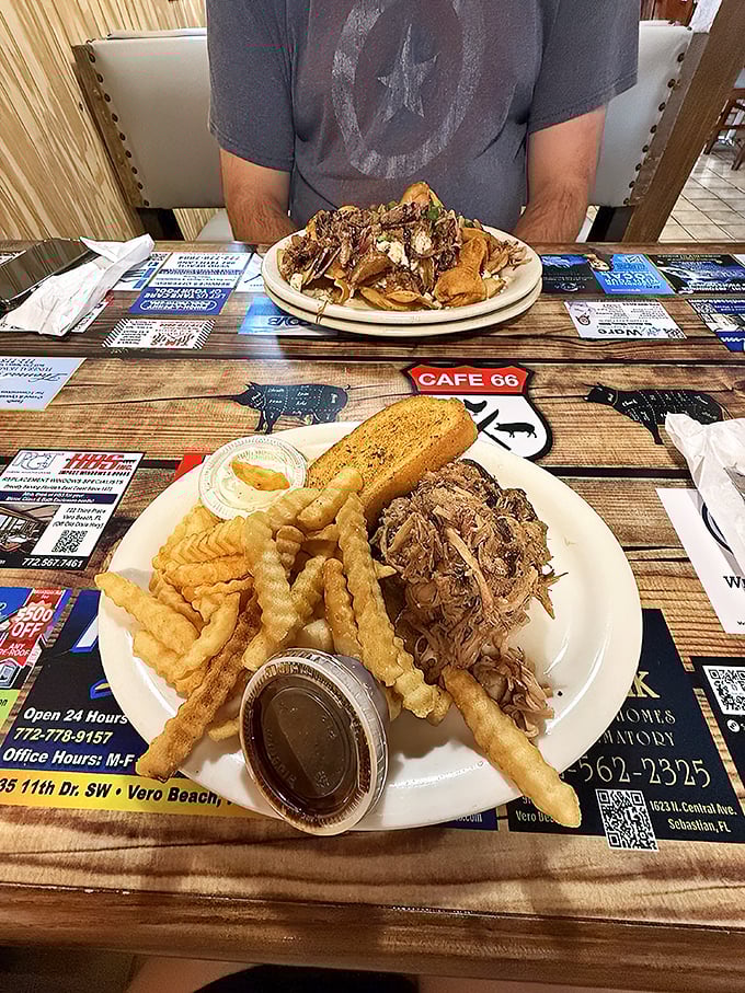 Pulled pork perfection meets crinkle-cut companions. The table placemats double as local advertising and conversation starters when your mouth is too full to talk.