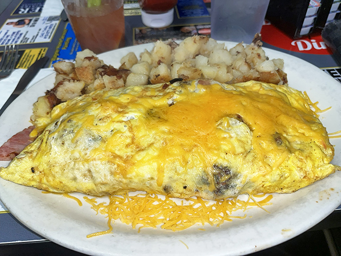 This isn't just an omelet &ndash; it's a golden sunrise on a plate, accompanied by home fries that could make a potato farmer weep with joy.