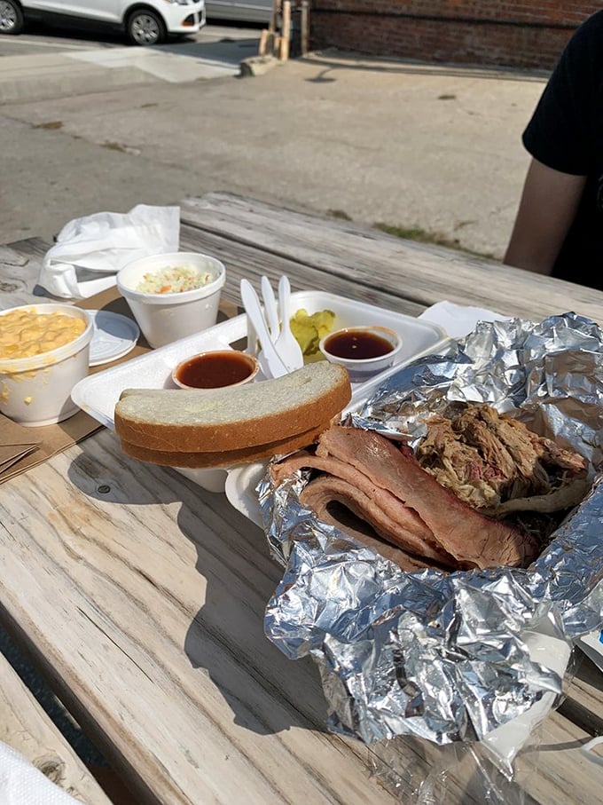 Foil-wrapped treasures unfold like Christmas morning for carnivores. The bread's just there to remind you civilization still exists outside this smoky paradise.