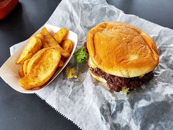 This isn't just a burger—it's edible proof that simplicity trumps pretension. Those golden potato wedges aren't just a side; they're co-stars.