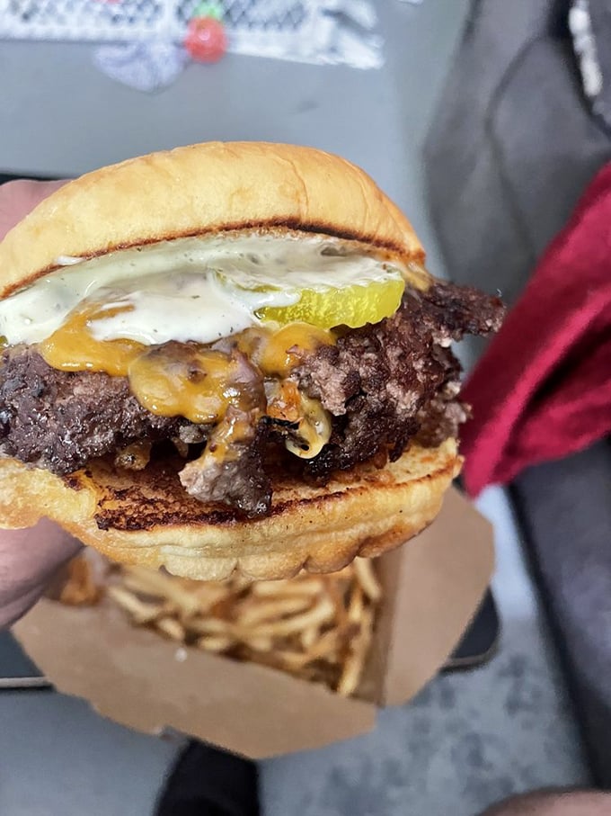 This isn't just a burger; it's a masterpiece of melty cheese cascading over crispy-edged beef, with pickle providing the perfect tang.