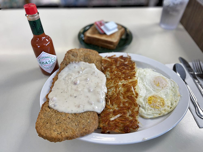 The star of the show: chicken fried steak wearing its gravy like a tailored suit, with hash browns so crispy they deserve their own fan club.