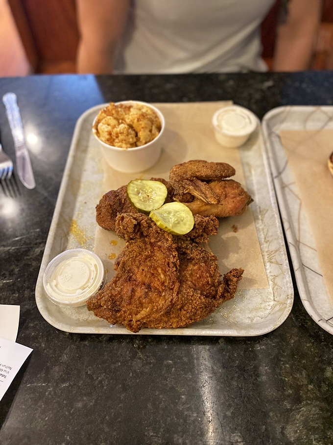 Golden-fried chicken resting on pickle slices alongside mac and cheese&mdash;proof that comfort food doesn't need fancy plating to be extraordinary.