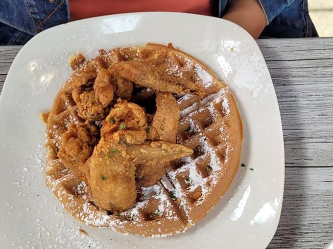 Golden-fried chicken perched atop a perfect waffle, dusted with powdered sugar. This isn't breakfast or lunch&mdash;it's edible joy on a plate.