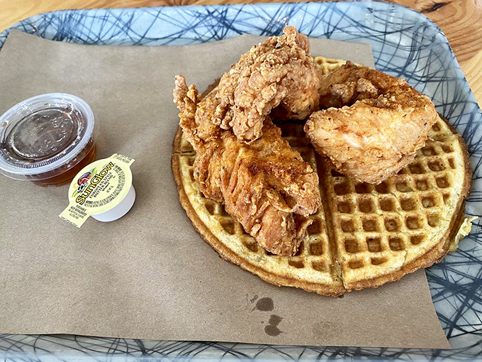 Golden-crisp chicken perched atop a waffle throne, accompanied by syrup in its formal attire&mdash;this isn't breakfast, it's edible royalty holding court.