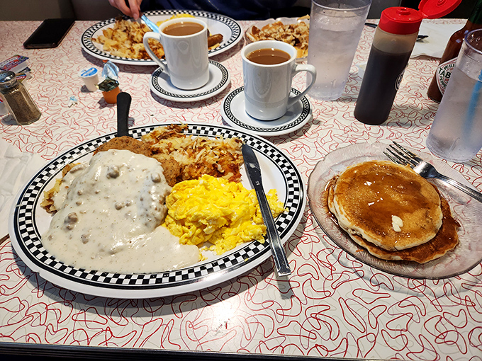 Breakfast nirvana achieved: biscuits smothered in peppery gravy alongside golden hash browns and fluffy scrambled eggs. The pancake is just showing off at this point.