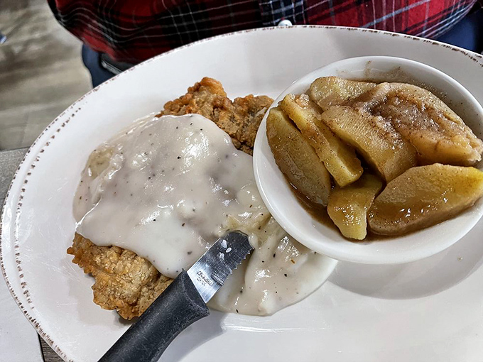 The legendary chicken fried steak arrives like royalty, draped in pepper gravy with a side of cinnamon-kissed fried apples. It's the kind of plate that makes you want to hug the chef.