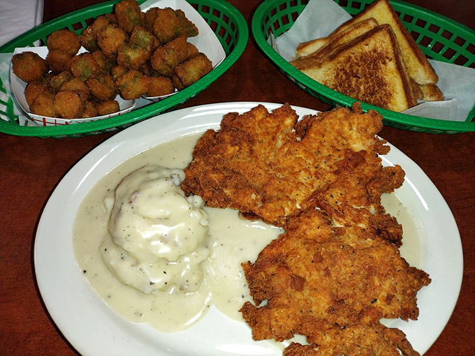 Chicken fried steak with a golden crust that shatters like childhood dreams, nestled beside creamy mashed potatoes and crispy okra. Comfort food nirvana achieved.