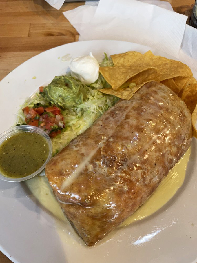 Behold the chimichanga in its natural habitat &ndash; gloriously golden, swimming in queso, and practically begging to be photographed before devoured.