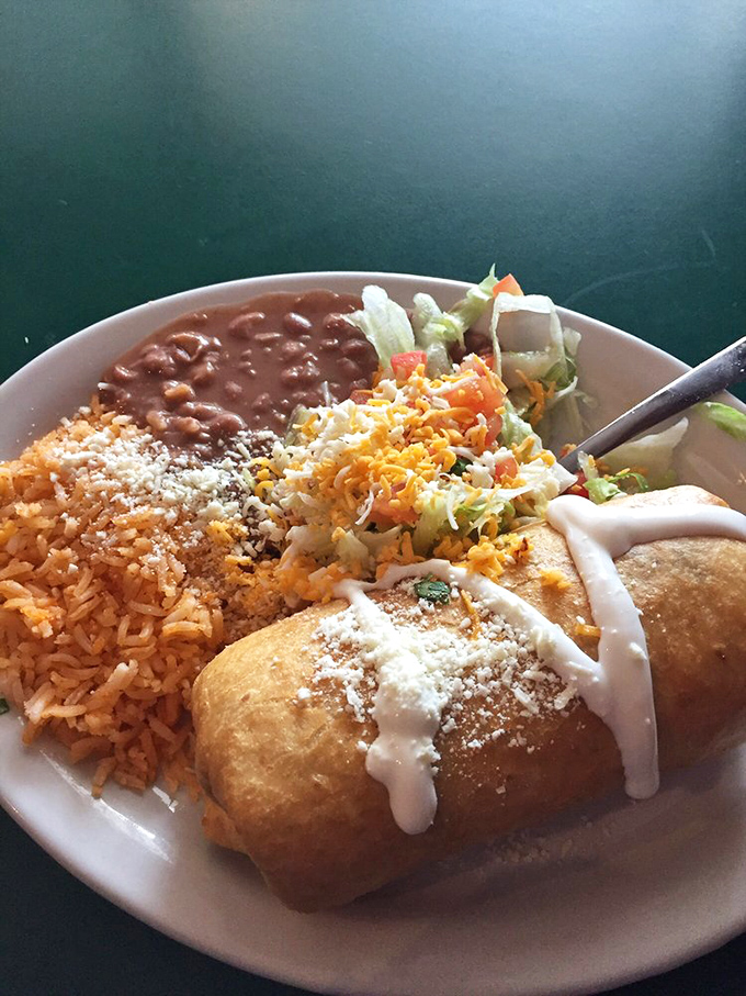 Behold the star of our show &ndash; a golden-fried chimichanga topped with cheese and sour cream, flanked by loyal sidekicks rice and beans.