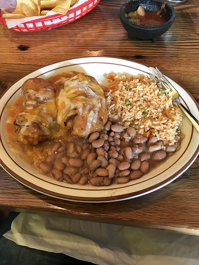 Comfort on a plate doesn't get more convincing than this &ndash; two plump burritos bathing in sauce alongside beans and rice that refuse to be mere sidekicks.