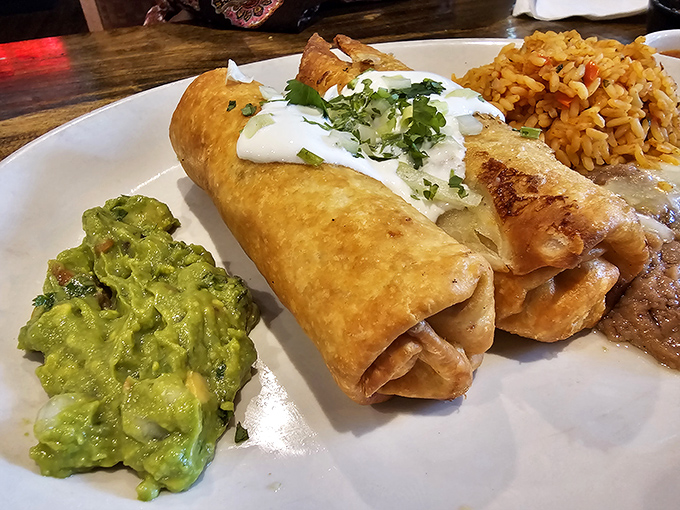 Golden-brown chimichanga perfection! That crispy exterior gives way to a tender filling, with guacamole standing by for creamy support.