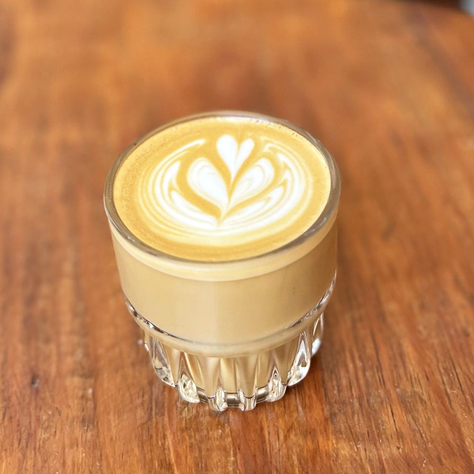 Latte art so precise it belongs in a museum, served in a glass that makes your morning coffee feel like an evening cocktail.
