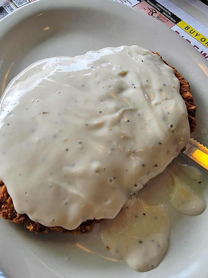 Behold the crown jewel: chicken fried steak swimming in a sea of peppery cream gravy so good you'll want to write poetry about it.