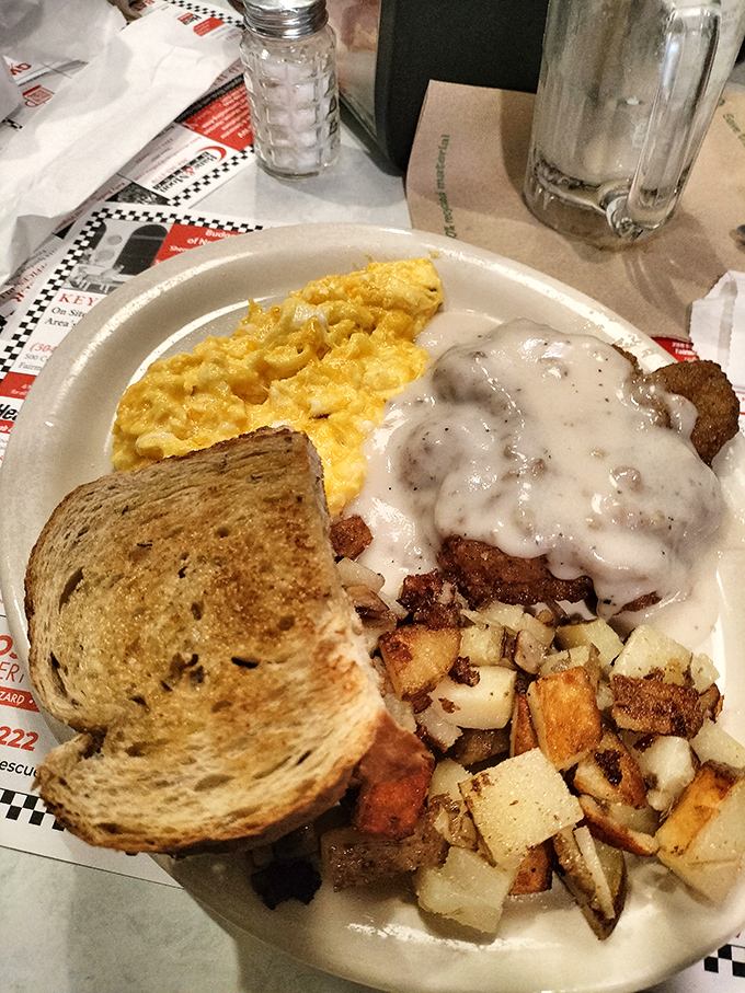 Behold the holy trinity of diner perfection: golden-crisp country fried steak, fluffy scrambled eggs, and home fries that demand to be savored.