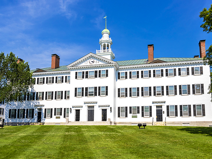 Dartmouth Hall gleams white against New Hampshire's blue skies. This colonial beauty has educated more future senators than most buildings have educated pigeons.