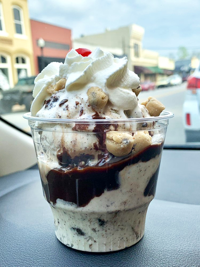 Layers of joy in a plastic cup—cookie chunks, ice cream, hot fudge, and whipped cream create a dashboard dessert worth risking upholstery for.