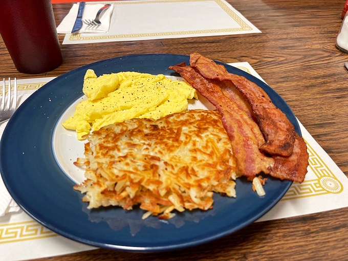 The breakfast trinity: perfectly sunny eggs, sausage links with that satisfying snap, and those legendary hash browns that make potato lovers weak in the knees.